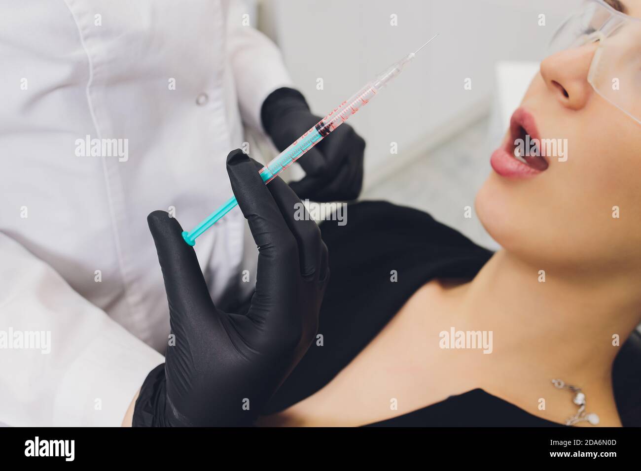 Dentist giving injection for anesthetizing his patient Stock Photo - Alamy