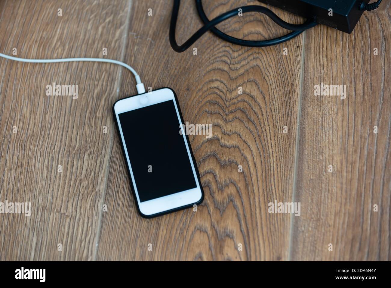 white smart phone extension lead on wooden table floor in charging ...