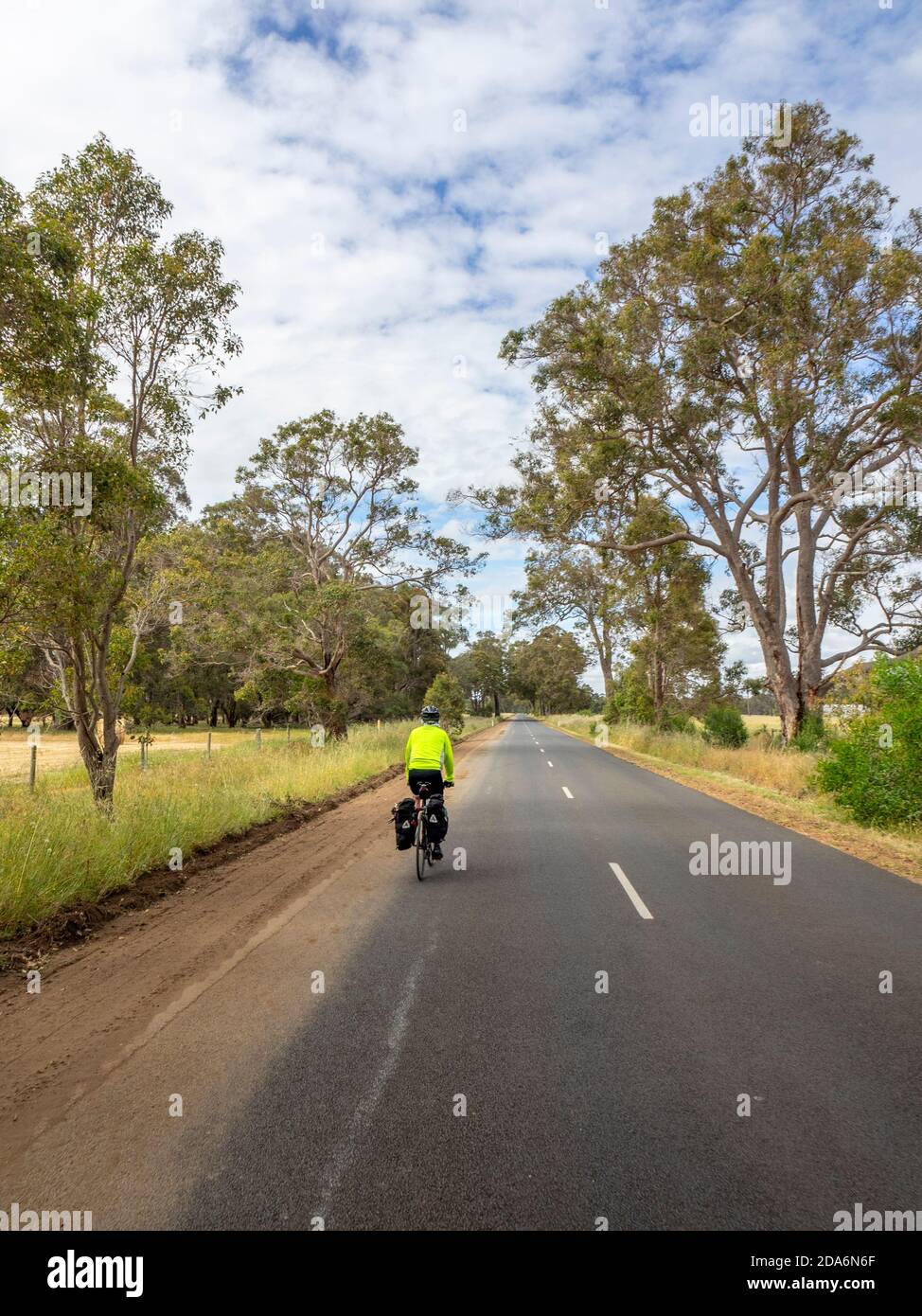 Touring cyclist travelling on vacation riding bicycle on a country road ...