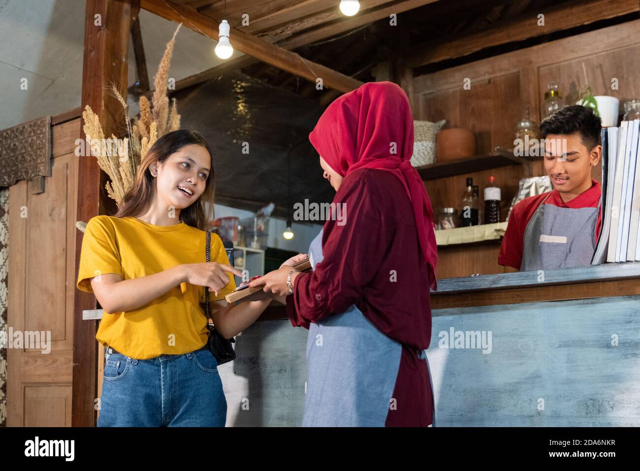 waiters shows the menu to the customer Stock Photo - Alamy