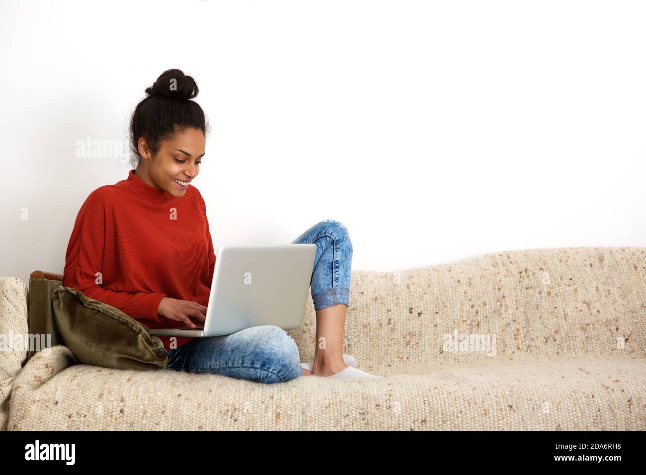 Full body portrait of attractive woman sitting on couch with laptop ...