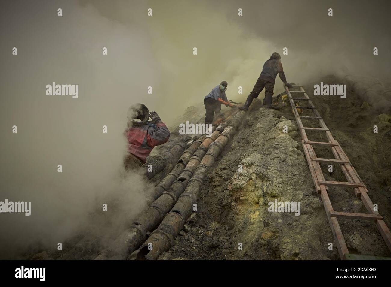 Sulphur miners working in the crater at kawah ijen hi-res stock ...