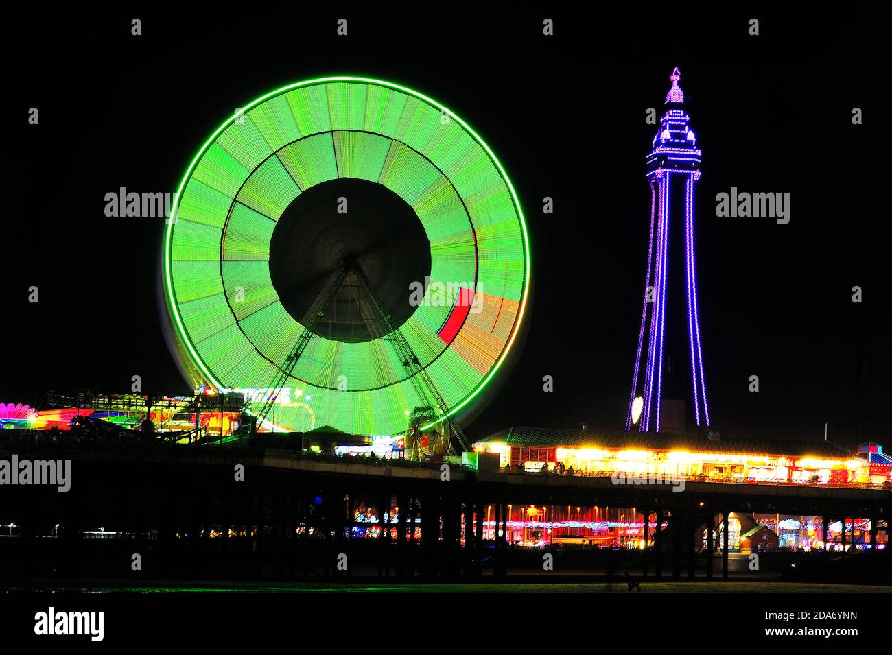 The many colours of Blackpool Tower and the Ferris wheel at night ...
