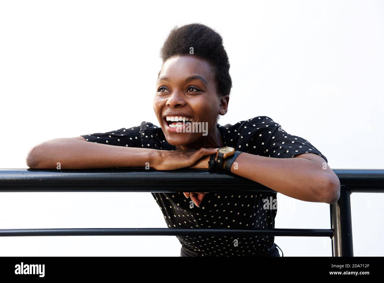 Close up portrait of young african woman leaning on railing and ...