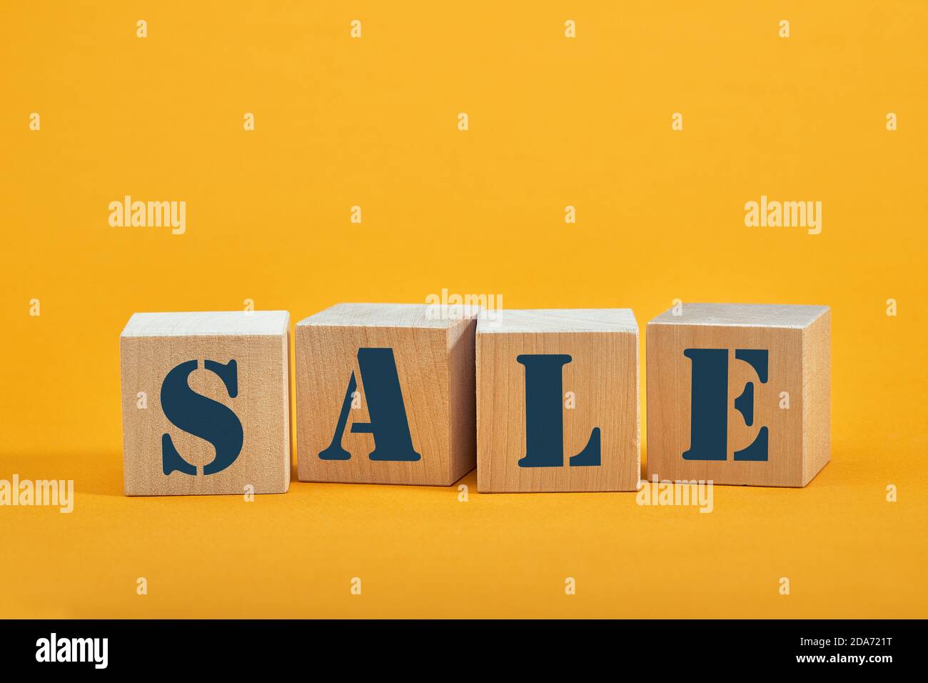 wooden blocks with the wordings SALE, isolated against yellow ...
