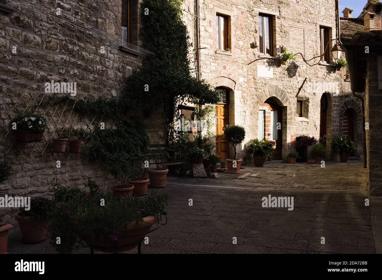 An alley of a medieval Italian village with stone houses, wooden doors ...