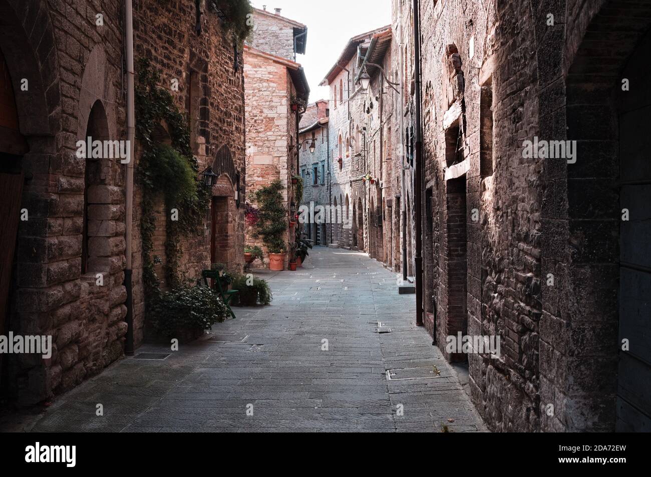 An alley of a medieval Italian village with stone houses, wooden doors ...