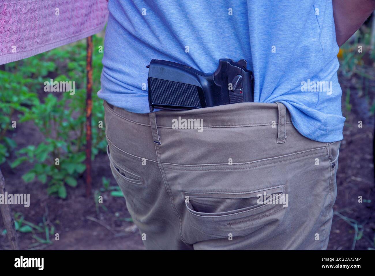 The gun is hidden behind man's back Stock Photo - Alamy