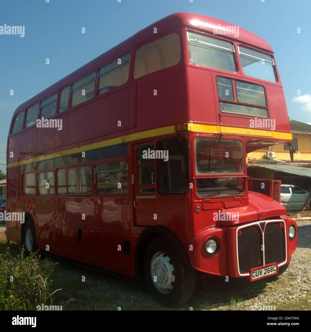 an old model double decker red bus parked in front of a house in Port ...