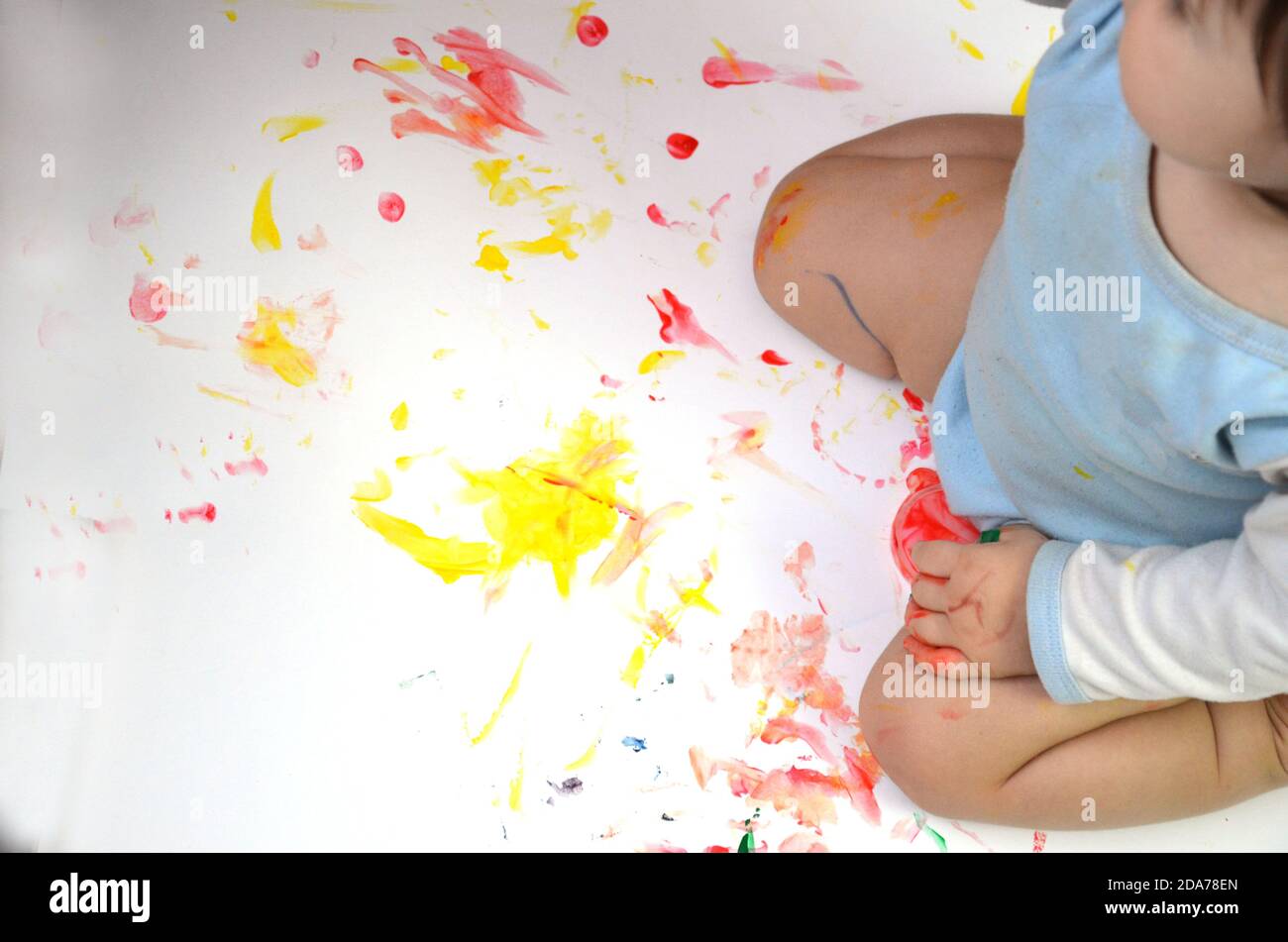 happy baby child draws with colored paints hands, fingers and palms are ...