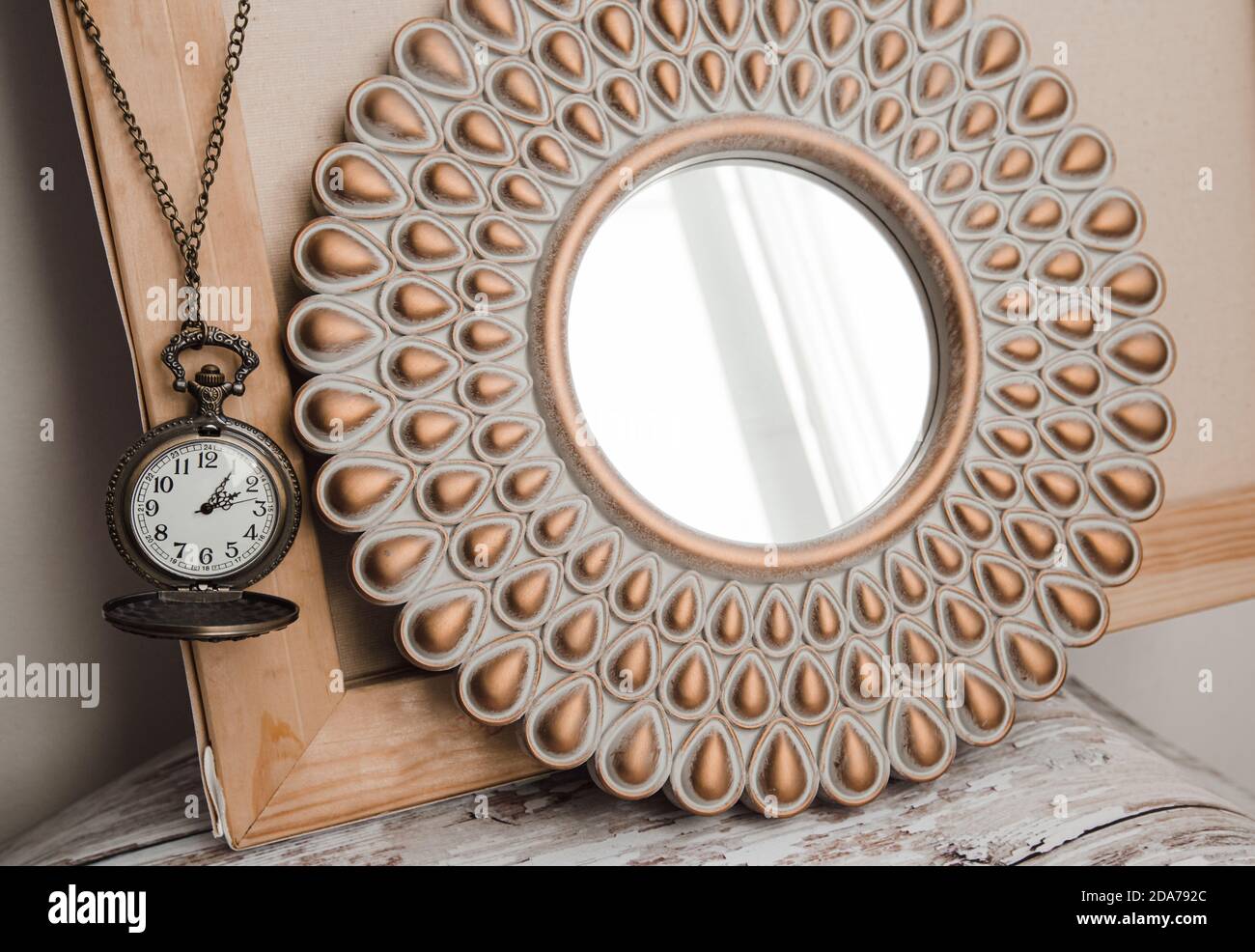 old round vintage clock on a chain next to a round mirror in the ...