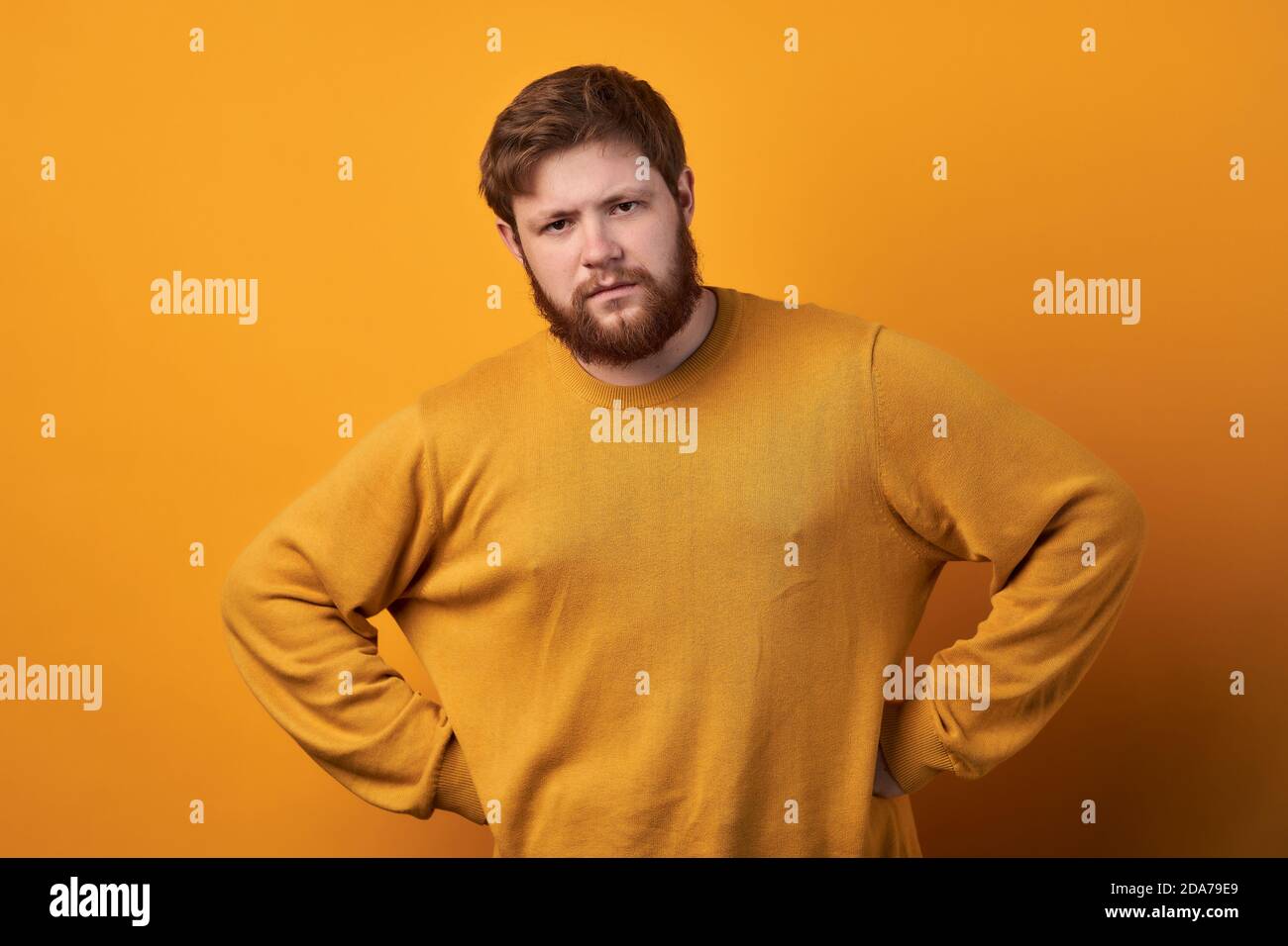 Beautiful bearded man with trendy haircut holding hands on waist ...