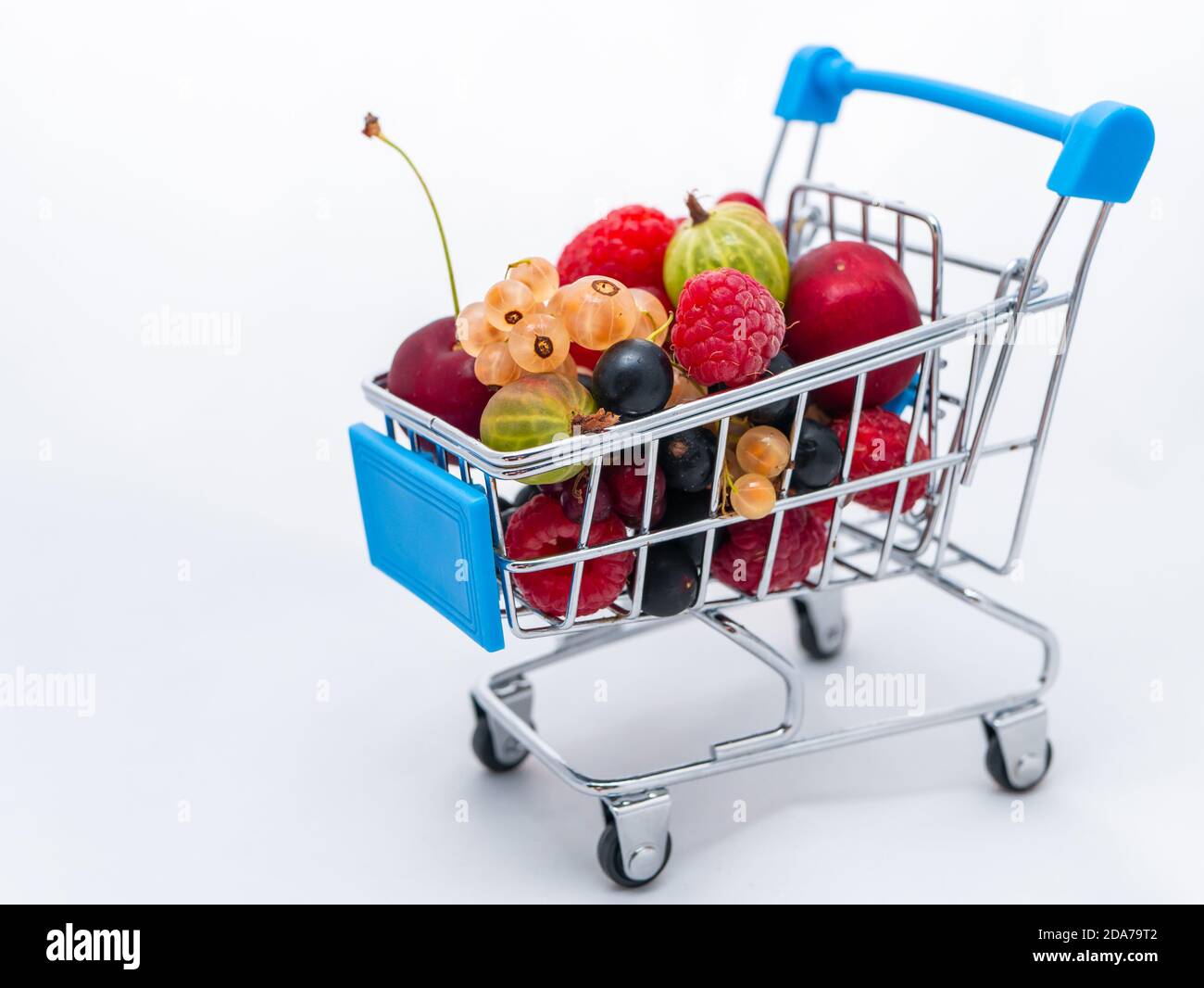 Mini grocery cart filled with fresh vitamin berries isolated on white ...