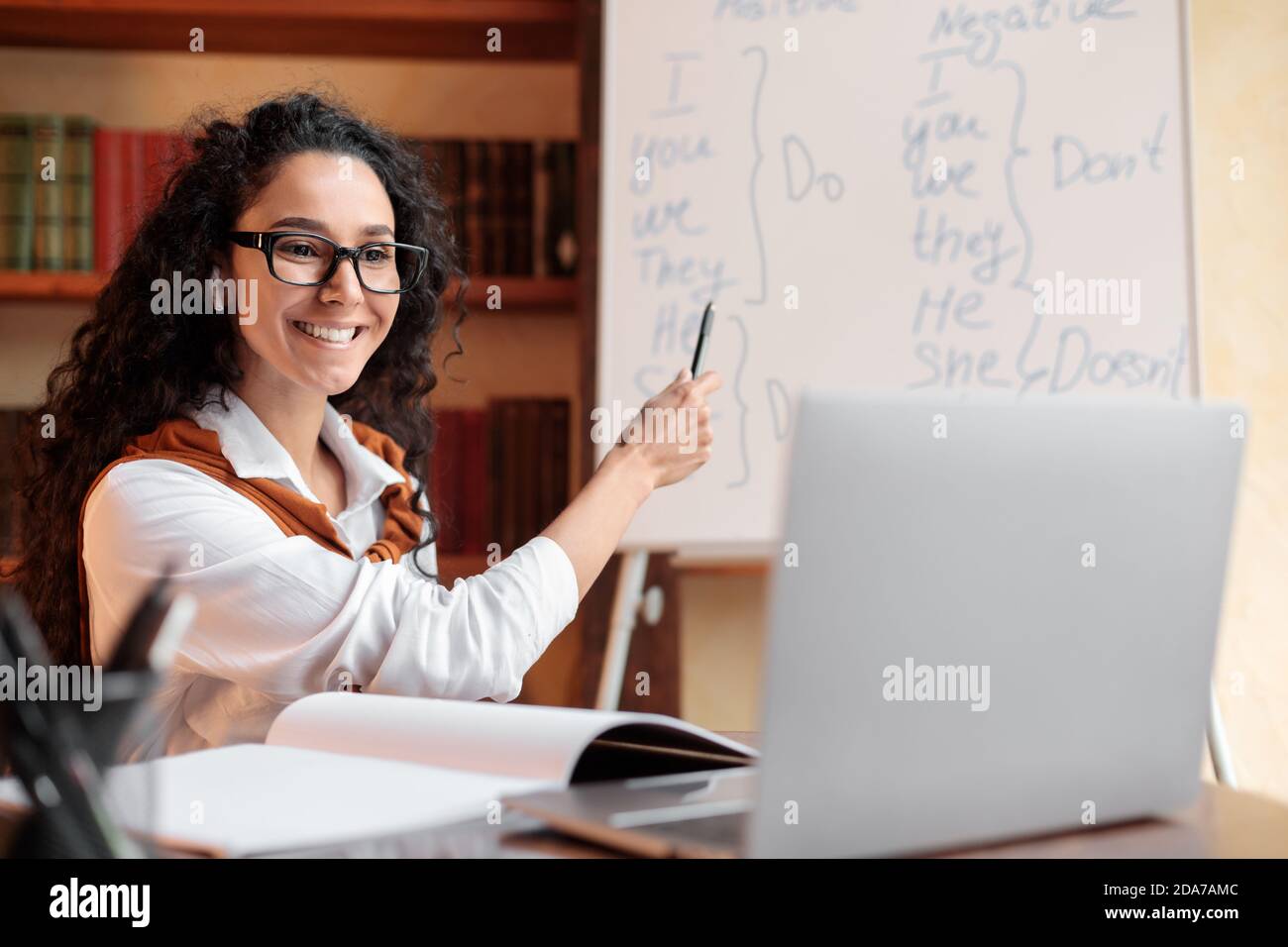 English teacher sitting at table, explaining lesson to students Stock ...
