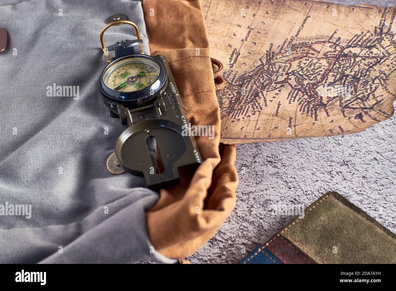 Top view closeup of a compass placed on a colorful fabric next to an ...