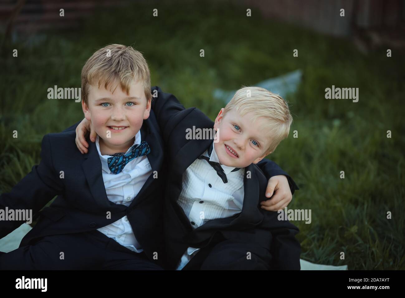Cute brothers wearing suits and posing shoulder to shoulder Stock Photo ...