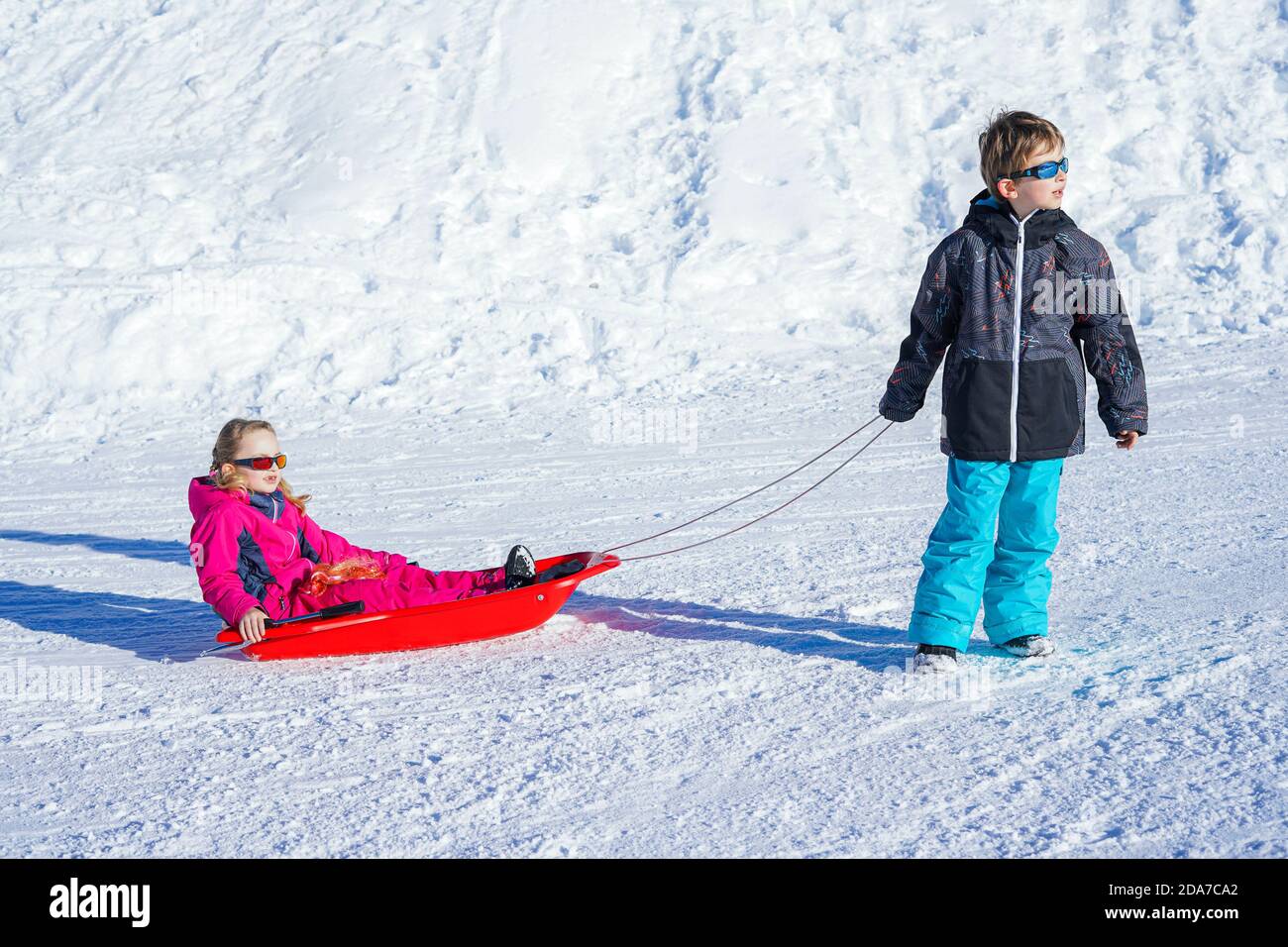 Brother pulling his sister kids toboggan sled snow. Little girl and boy ...