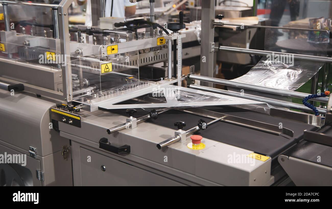 Shrink film wraping machine in food industry Stock Photo - Alamy