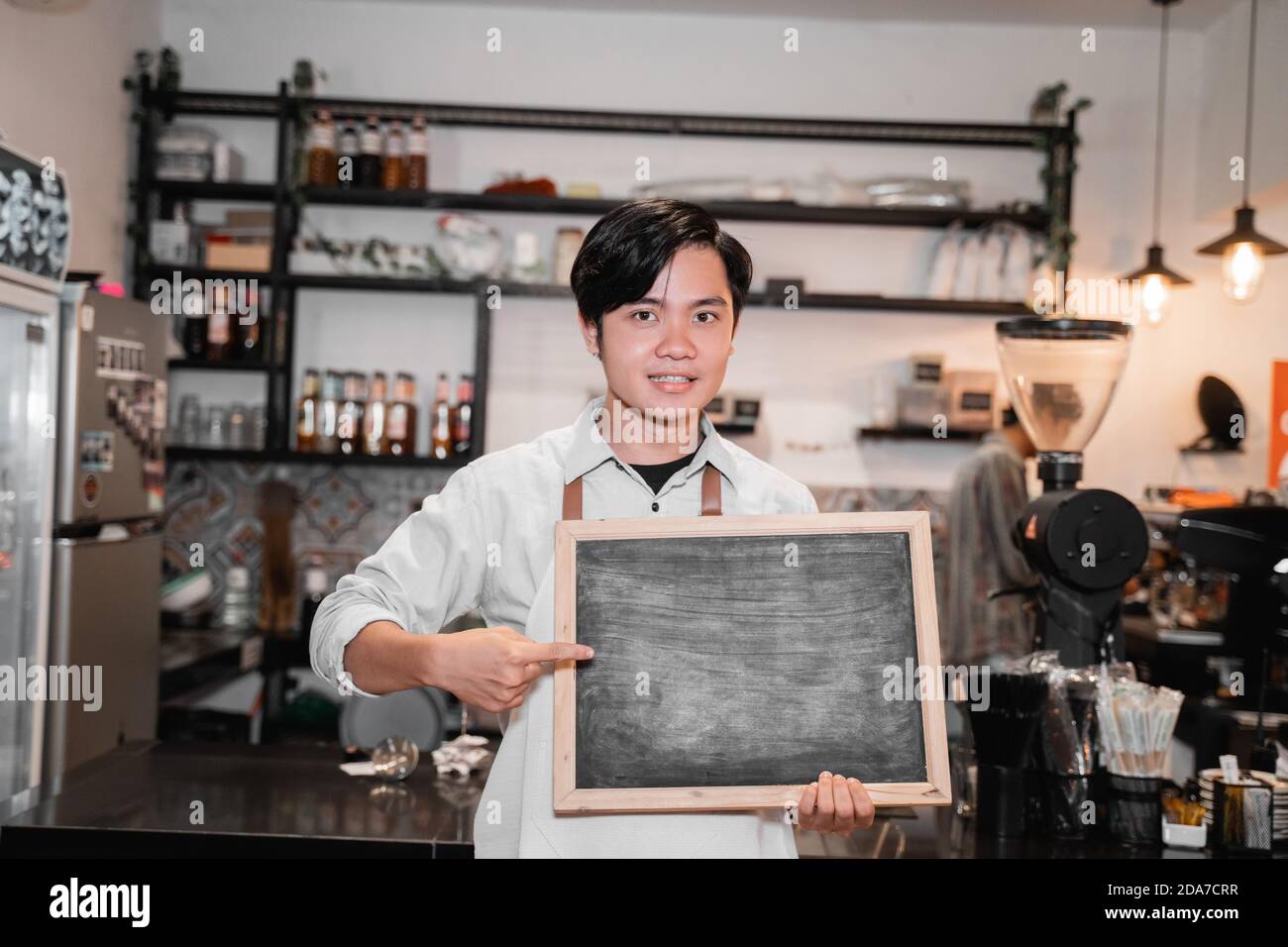 Handsome barista holding pointing hi-res stock photography and images ...