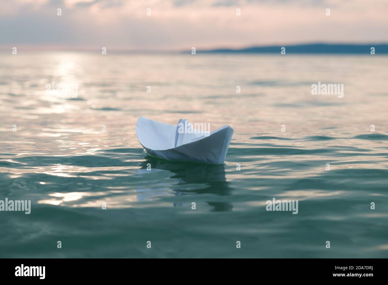 origami paper boat on water causing waves and ripples Stock Photo - Alamy