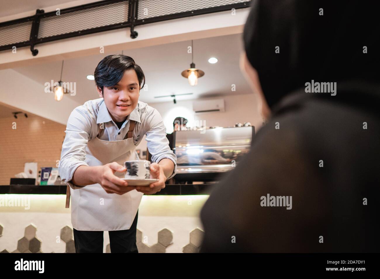 Waitress offering a cup of coffee for girl customer in coffee shop ...