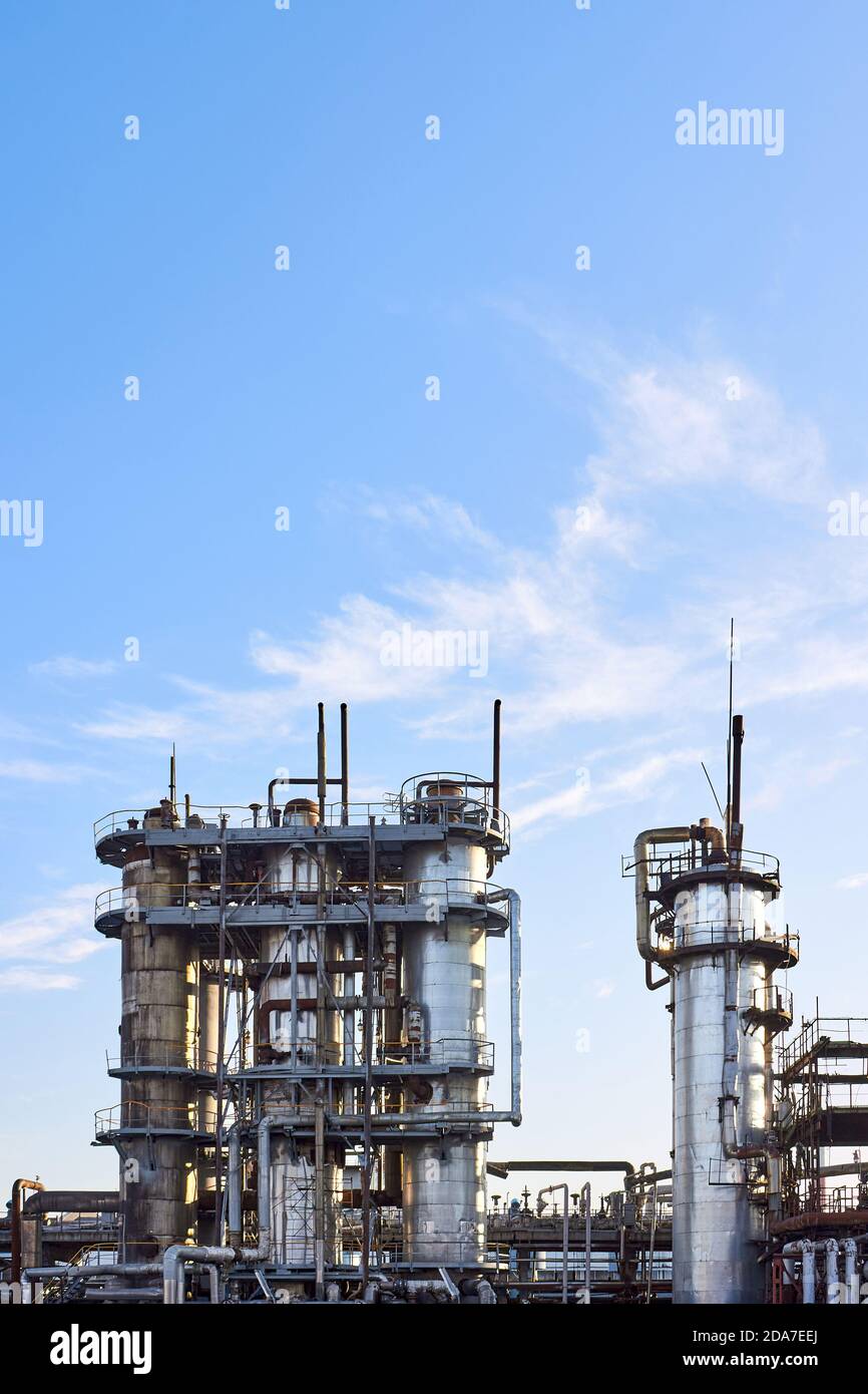 Old distillation column towers with blue sky with clouds background at ...