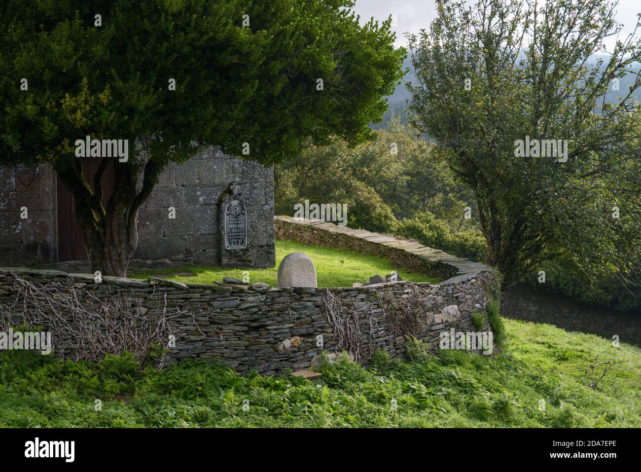 Small church with cemetery surrounded by a stone wall in a small ...