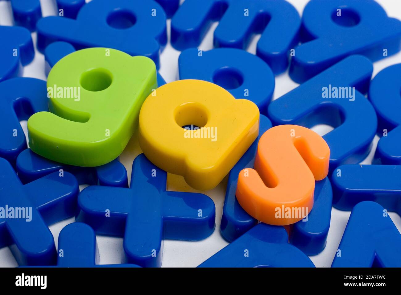 Coloured plastic letters still life shot against a plain white ...