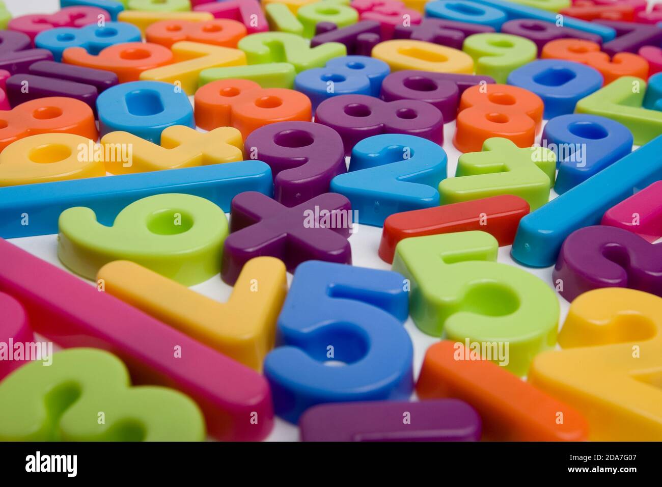 Colourful plastic fridge magnet style numbers and symbols still life ...