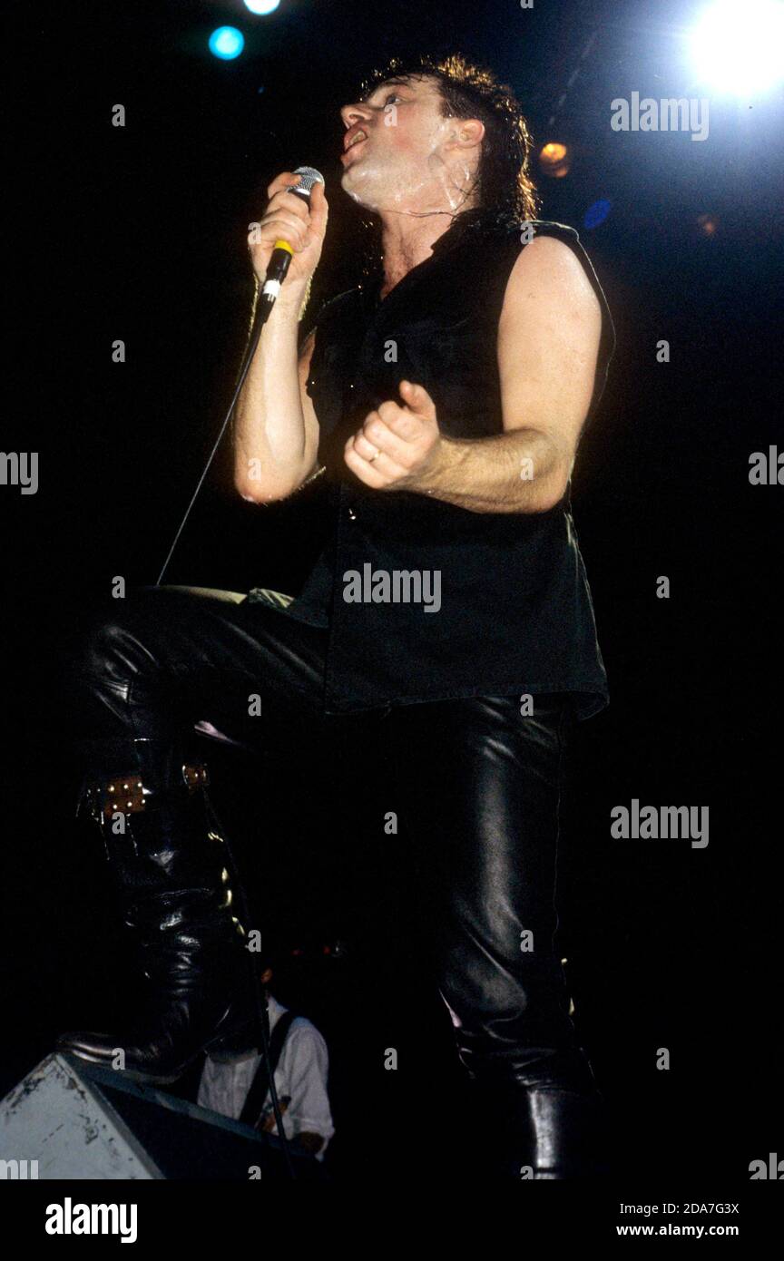 U2's Bono performing live at a concert on The Unforgettable Fire tour ...
