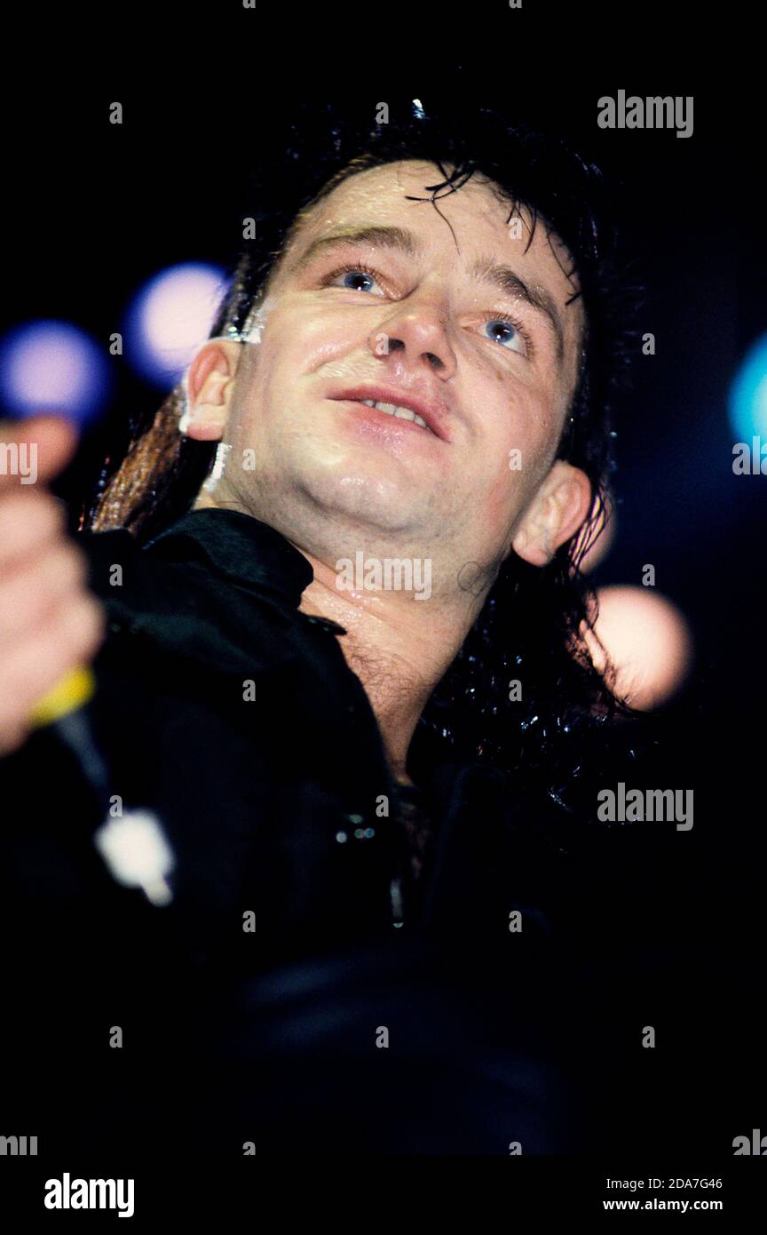 U2's Bono performing live at a concert on The Unforgettable Fire tour ...