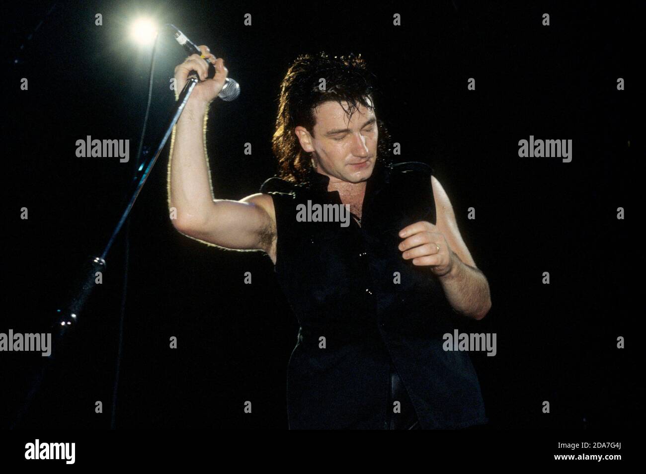 U2's Bono performing live at a concert on The Unforgettable Fire tour ...