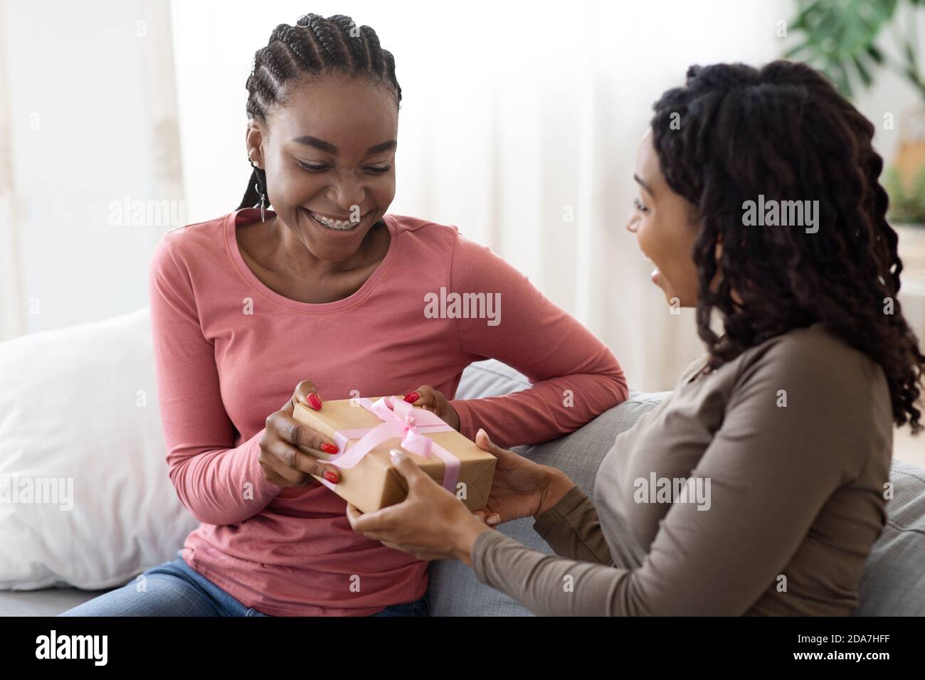 Smiling pretty black woman giving gift to her girlfriend Stock Photo ...