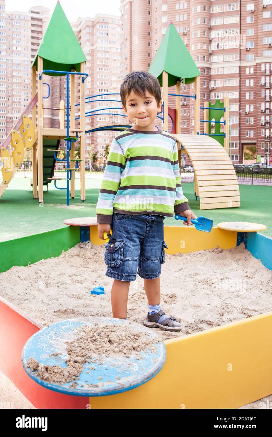 Cute boy playing in sandbox with a sand toys Stock Photo - Alamy