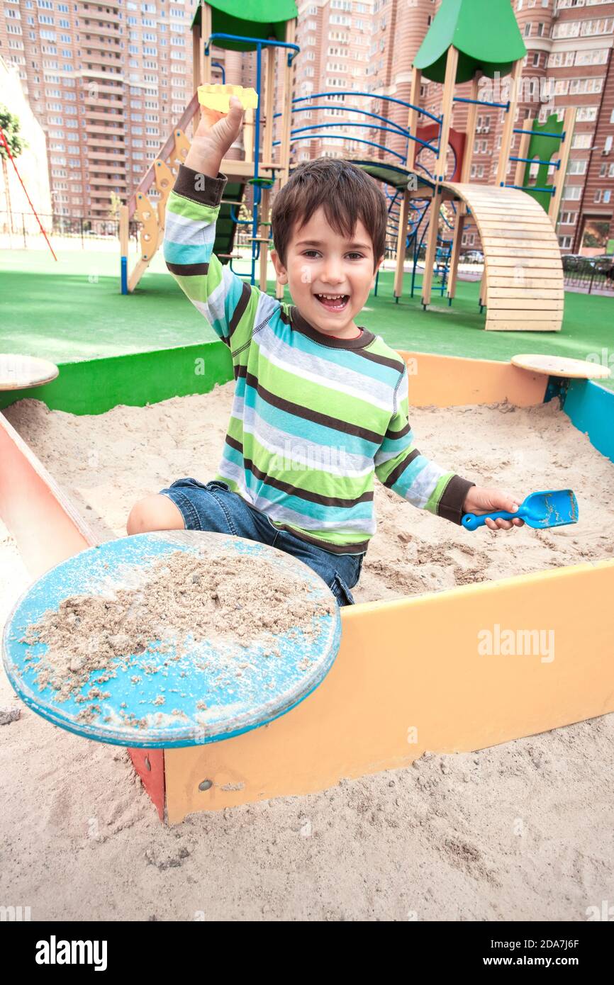 Cute boy playing in sandbox with a sand toys Stock Photo - Alamy