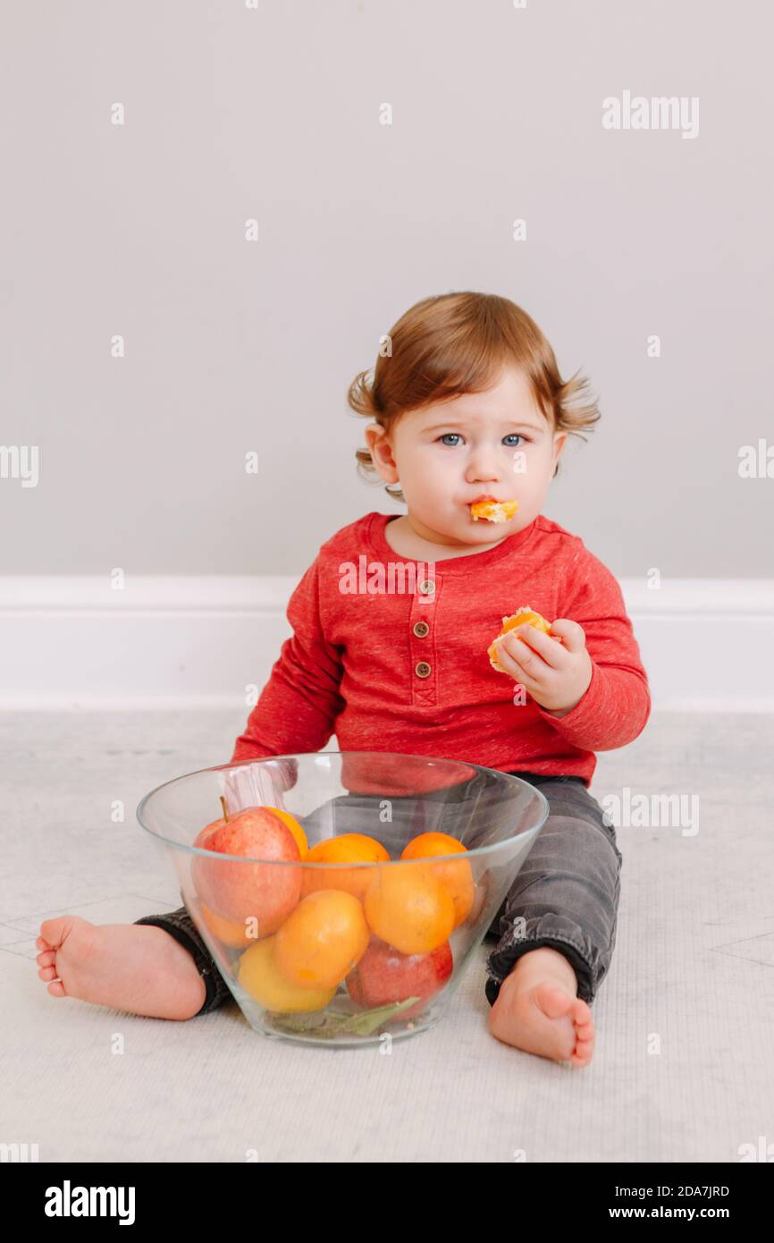Cute adorable Caucasian baby boy eating citrus fruit. Finny child ...