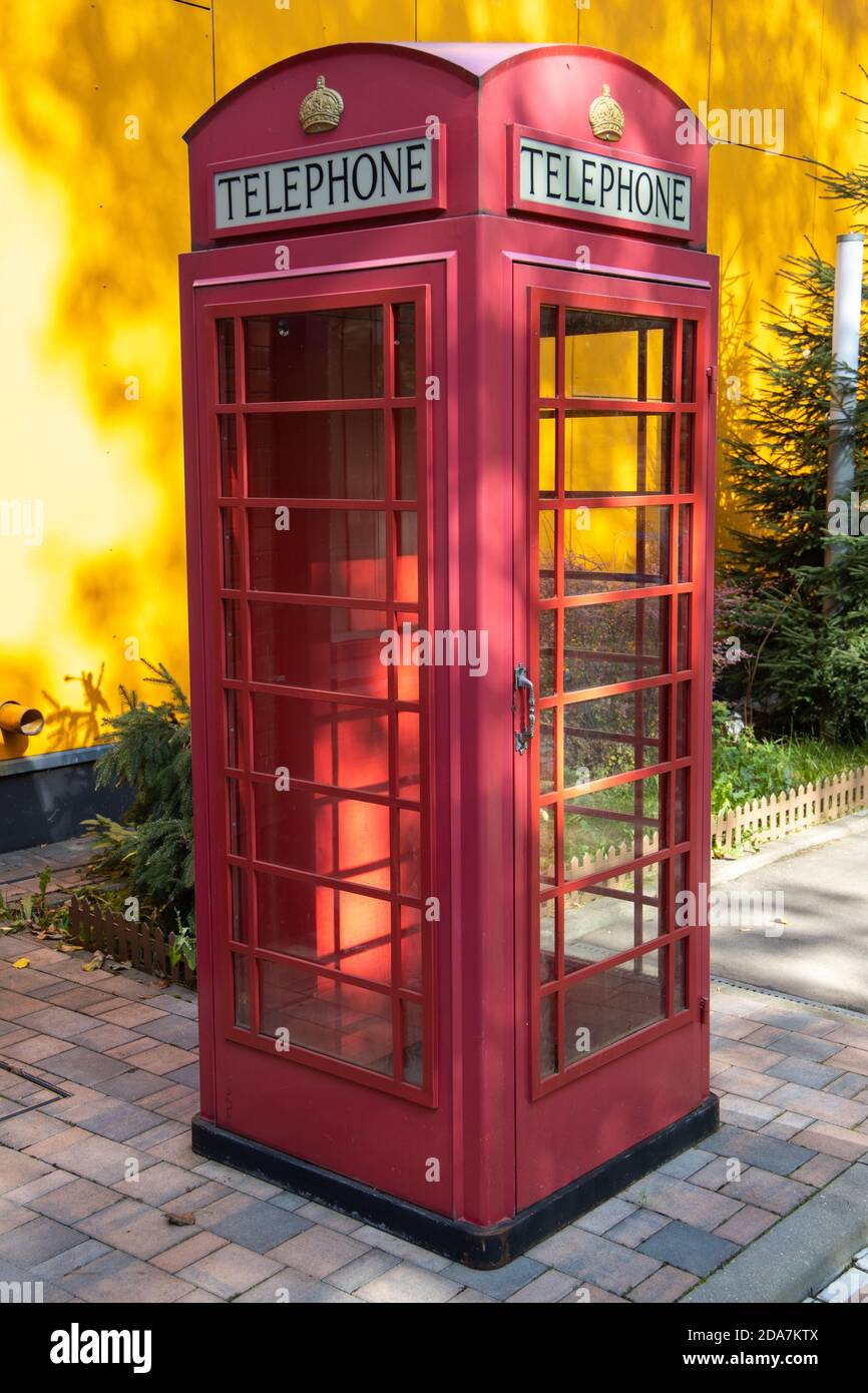 Traditional Red British Telephone Box Against a yellow Wall Stock Photo ...