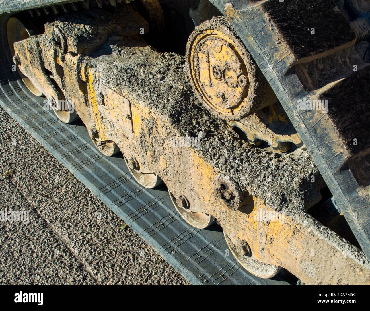 closeup of the mud caked undercarriage and track of a small bulldozer ...