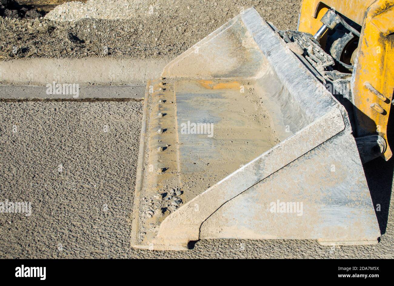 large empty bulldozer shovel covered with dirt during road work with ...