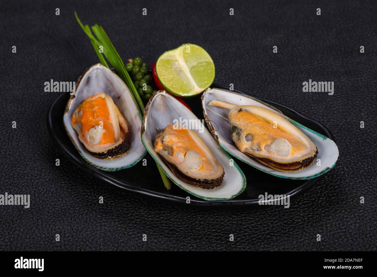 Half mussels with lime and green pepper Stock Photo - Alamy