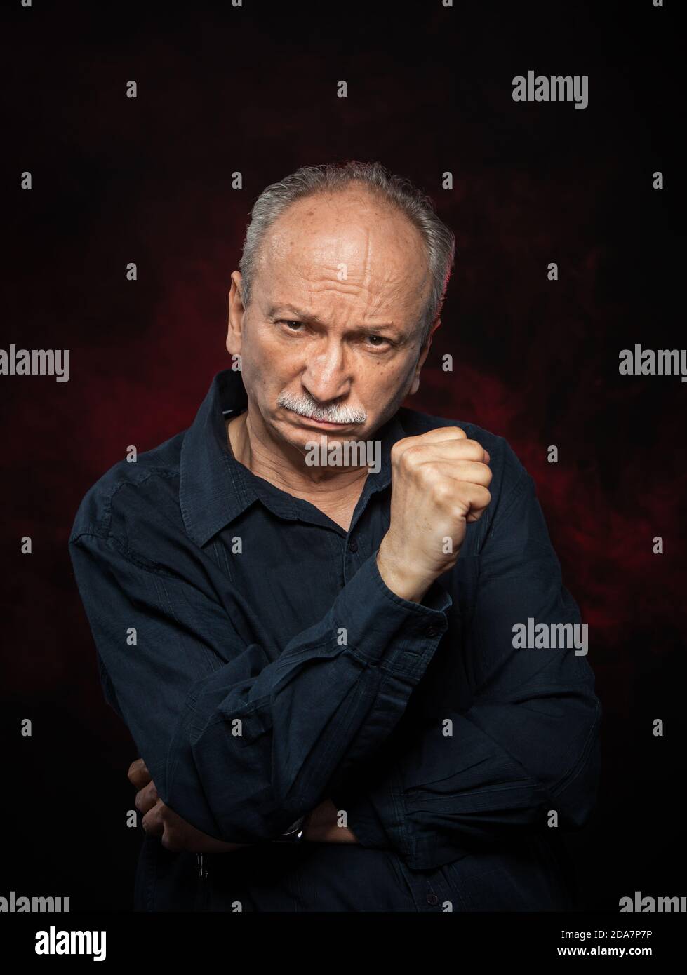 Old macho man. Portrait of an elderly emotional man on a dark ...