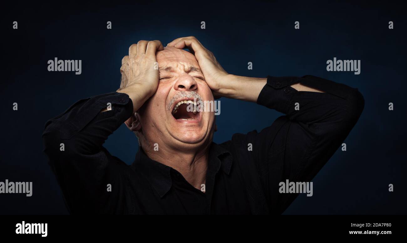 Old macho man. Scream of despair of an elderly man who holds his hands ...