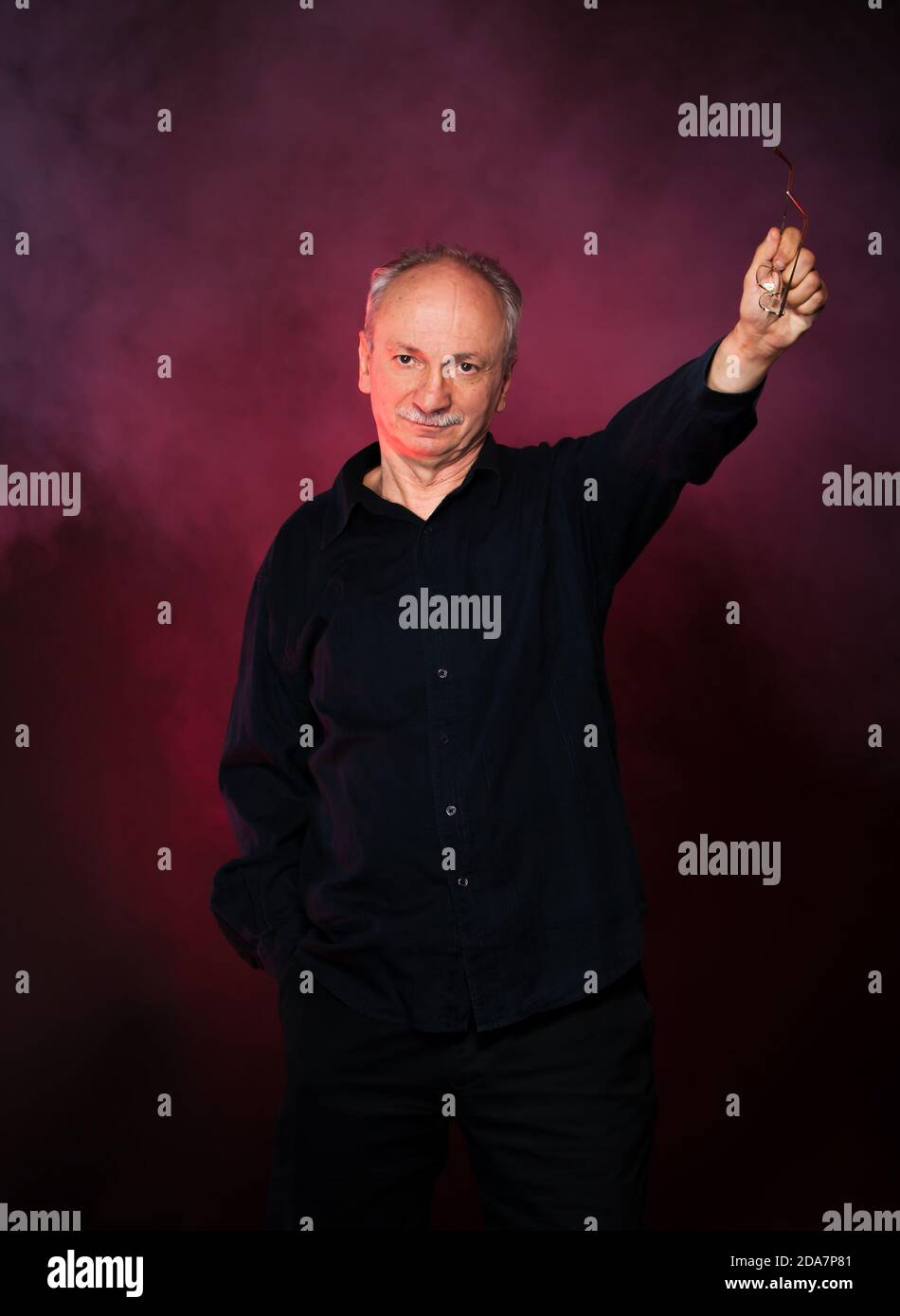 Old macho man. Portrait of an elderly emotional man on a dark ...