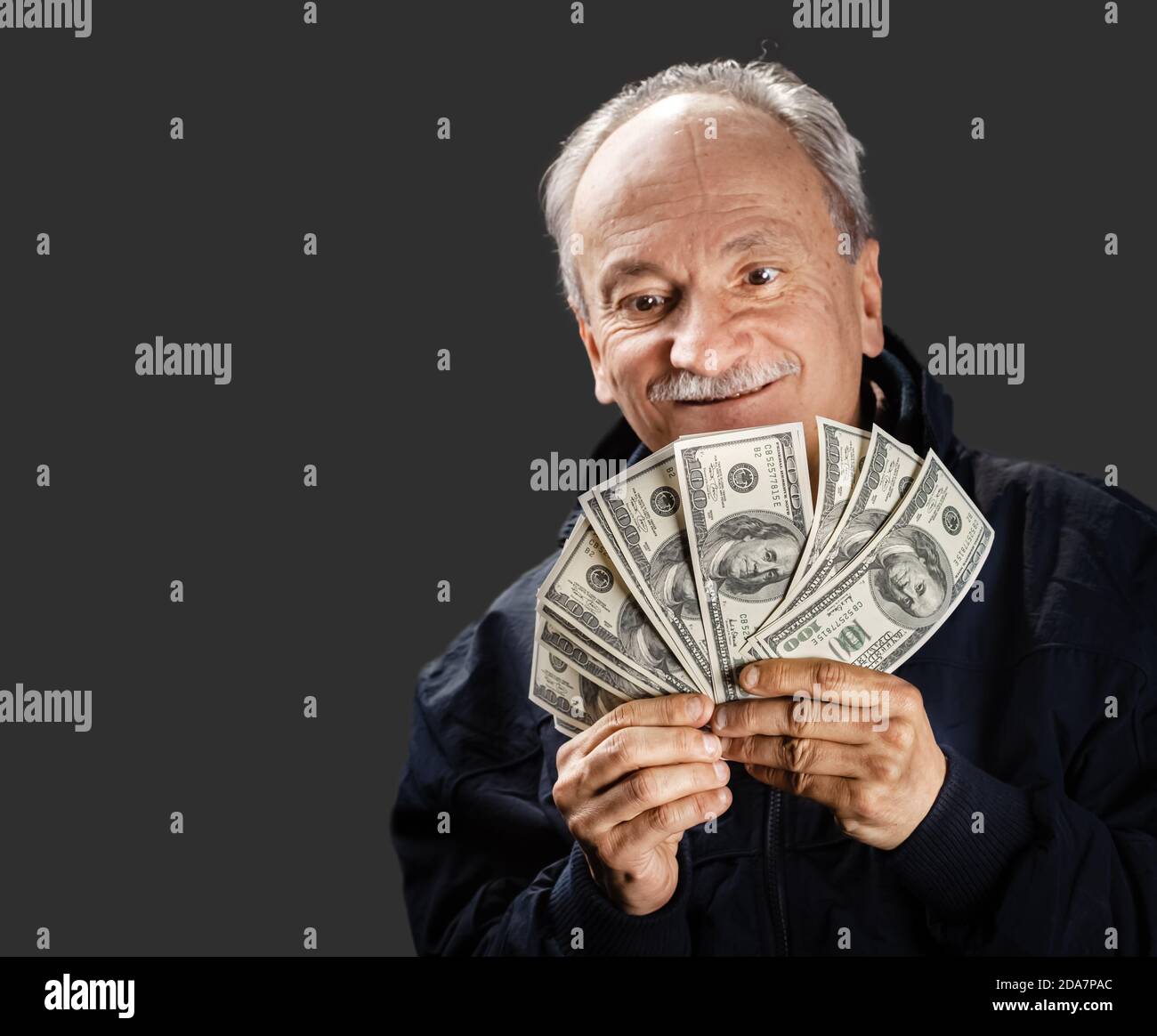 Senior gentleman holding a stack of money. Portrait of an excited old ...