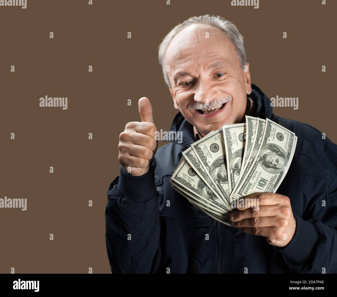 Senior gentleman holding a stack of money. Portrait of an excited old ...