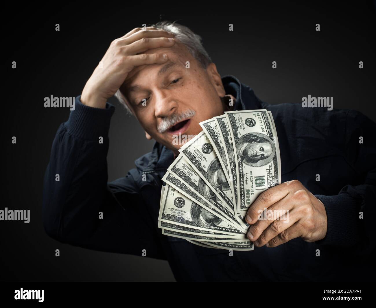 Senior gentleman holding a stack of money. Portrait of an excited old ...