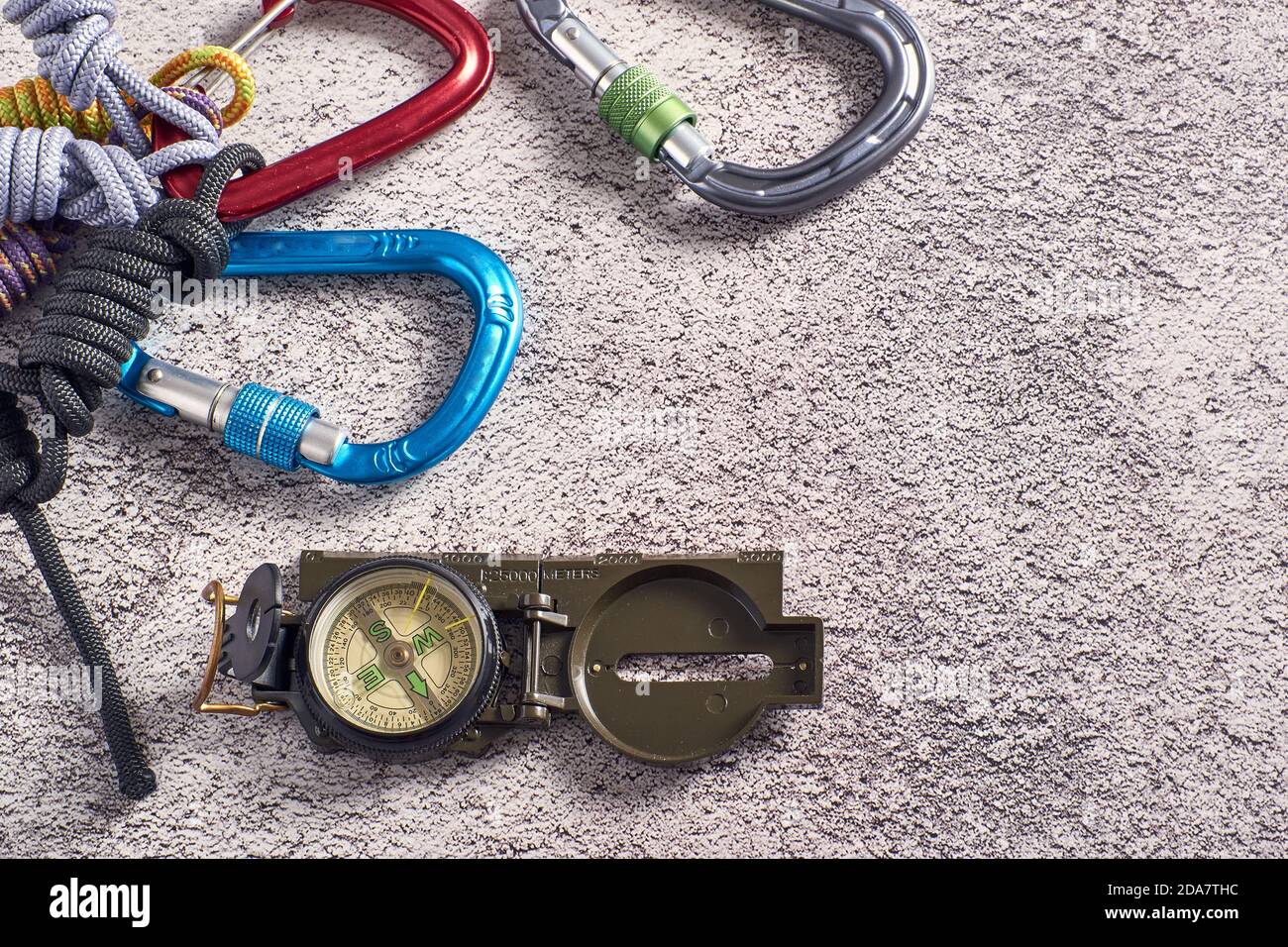 Top view closeup of colorful carabiners and a compass placed on the ...