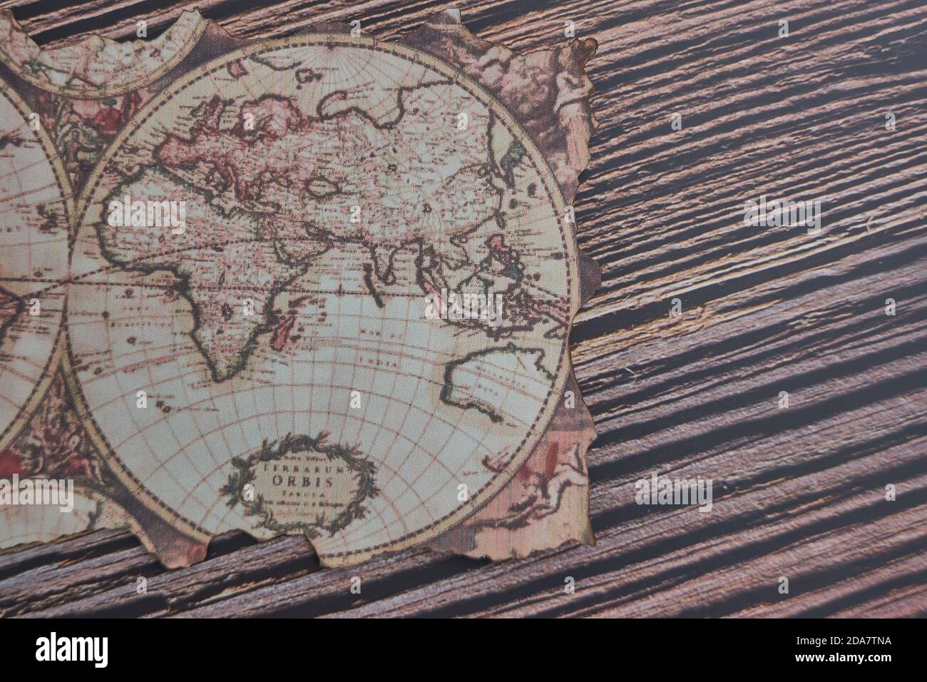 Top view on an old ancient map of the world placed on a wooden table ...