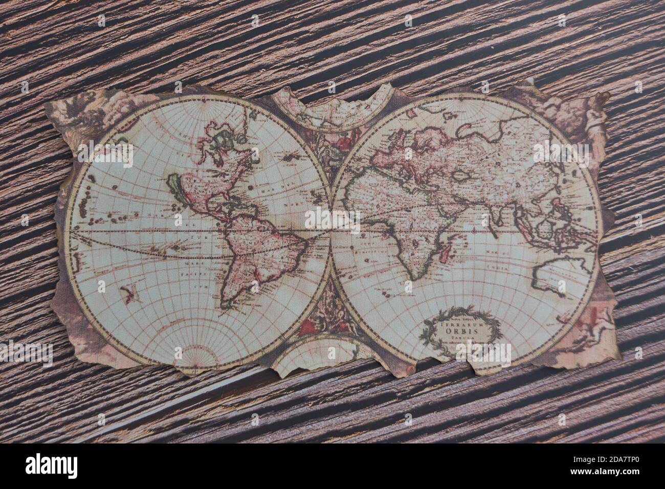 Top view on an old ancient map of the world placed on a wooden table ...