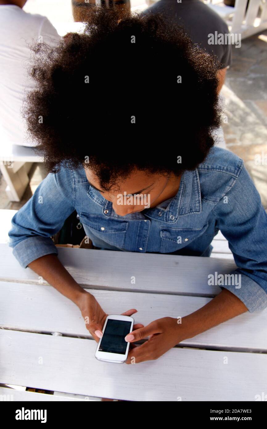 Close up portrait from above of attractive woman sitting outside ...